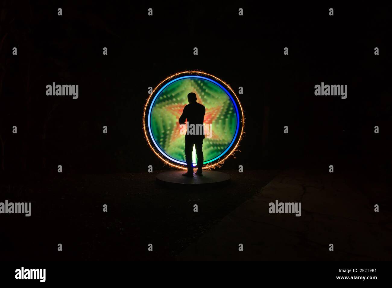One person standing alone against beautiful color circle LED light ...
