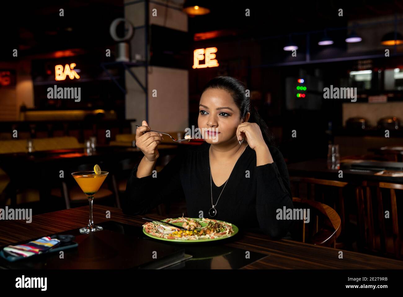 Portrait of a pretty woman eating delicious food in a restaurant Stock ...