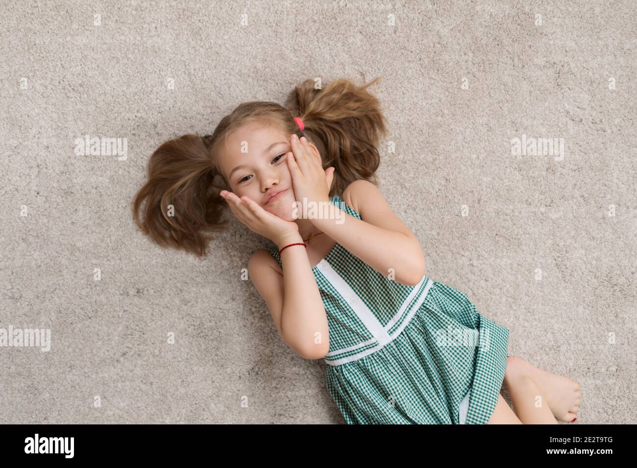 Cute preschool girl making funny faces, playing, having fun while lying ...