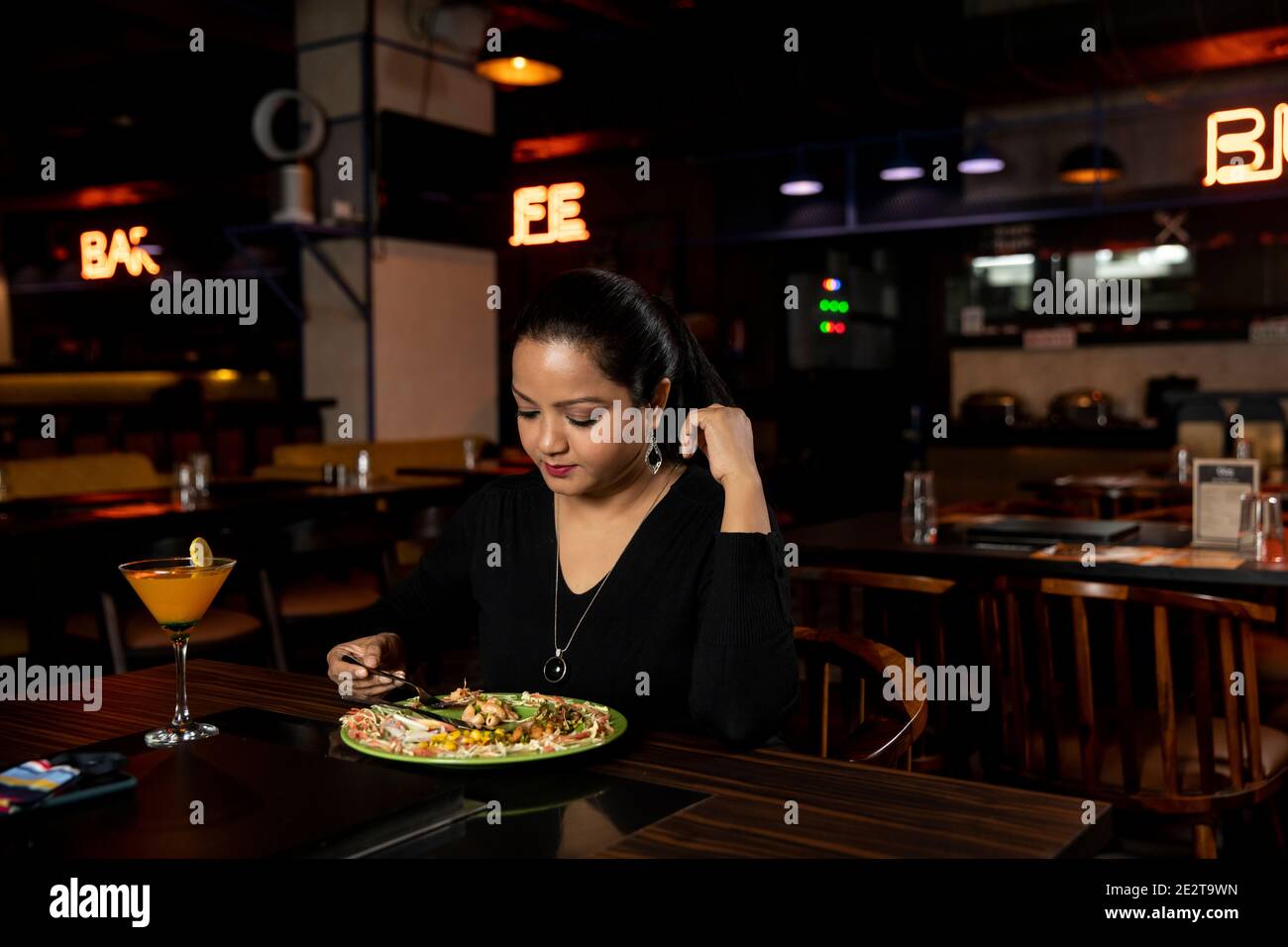Portrait of a pretty woman eating delicious food in a restaurant Stock ...