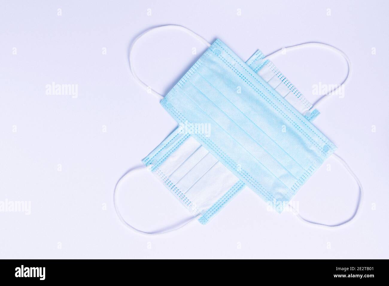 Two cross shaped disposable medical masks on a white background with ...