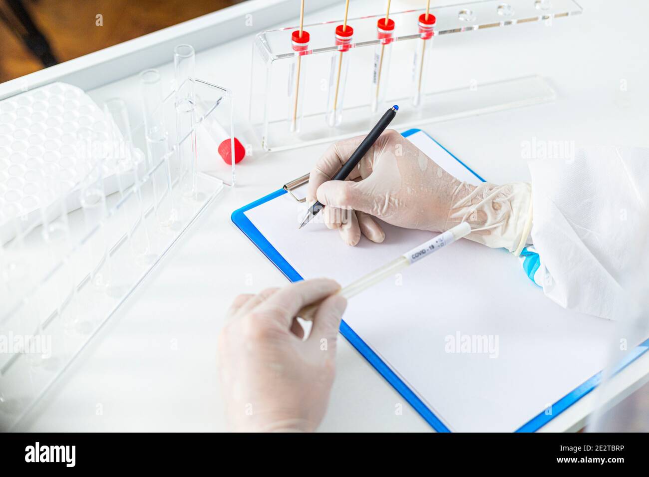 Medical worker in PPE holding positive COVID-19 test in hospital lab ...