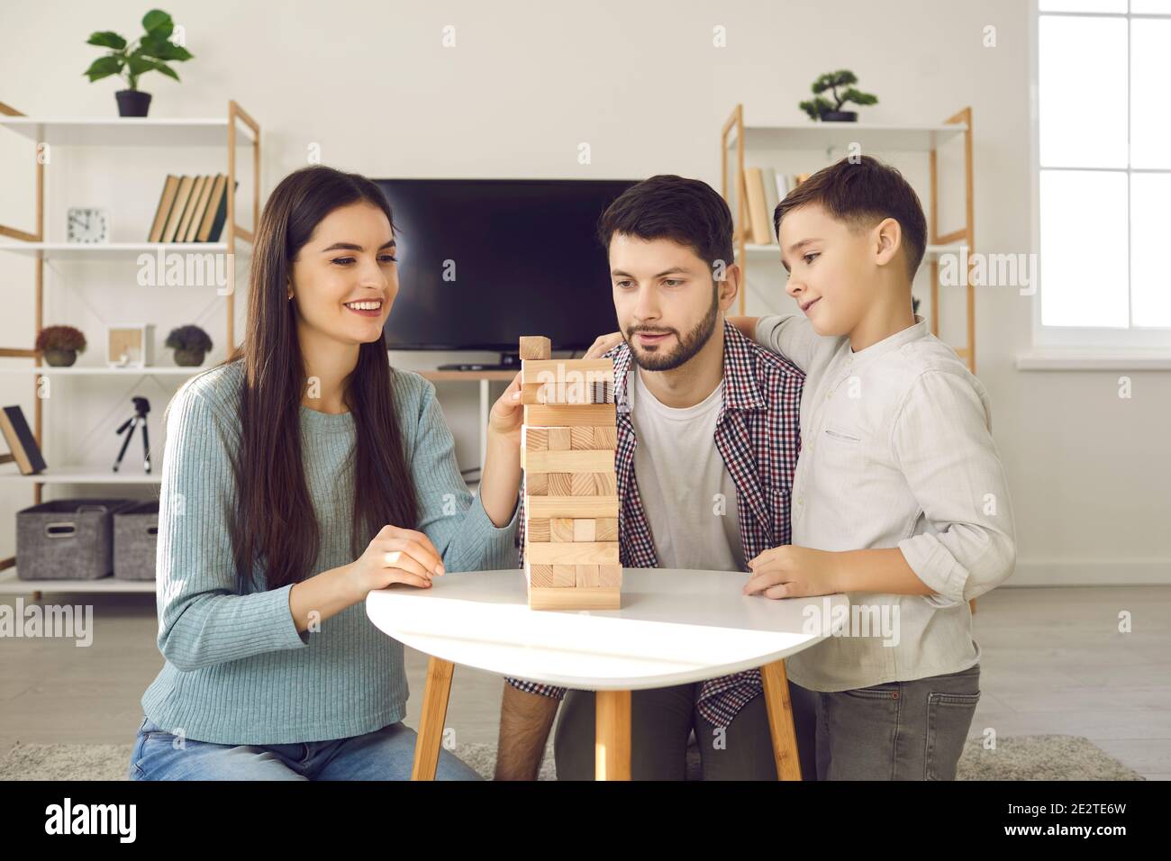 Happy family with child playing jenga while enjoying quiet indoor ...