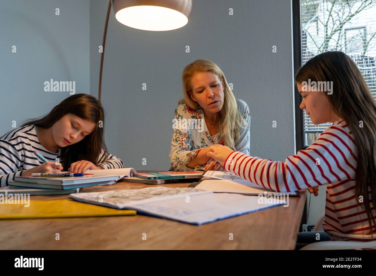 Homeschooling, during the lockdown in January 2021, mother helps her ...