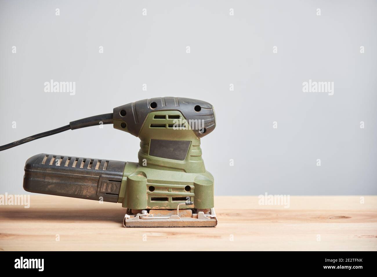 Electric sander on a pine wood plank, carpentry tool. Image with copy ...