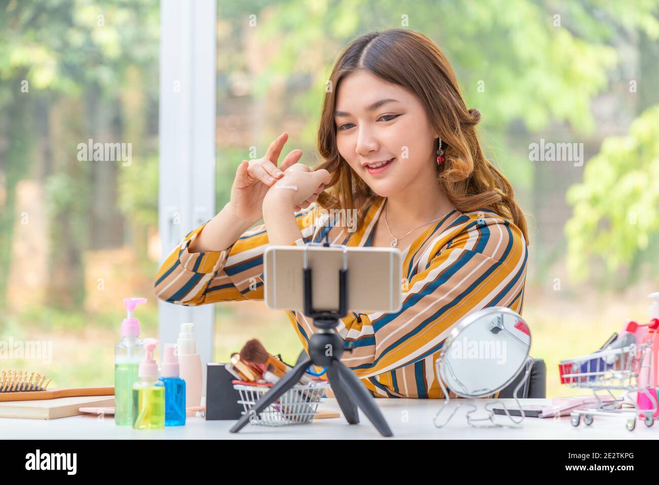 Happy beautiful young Asian woman, vlogger, reviewing beauty products ...