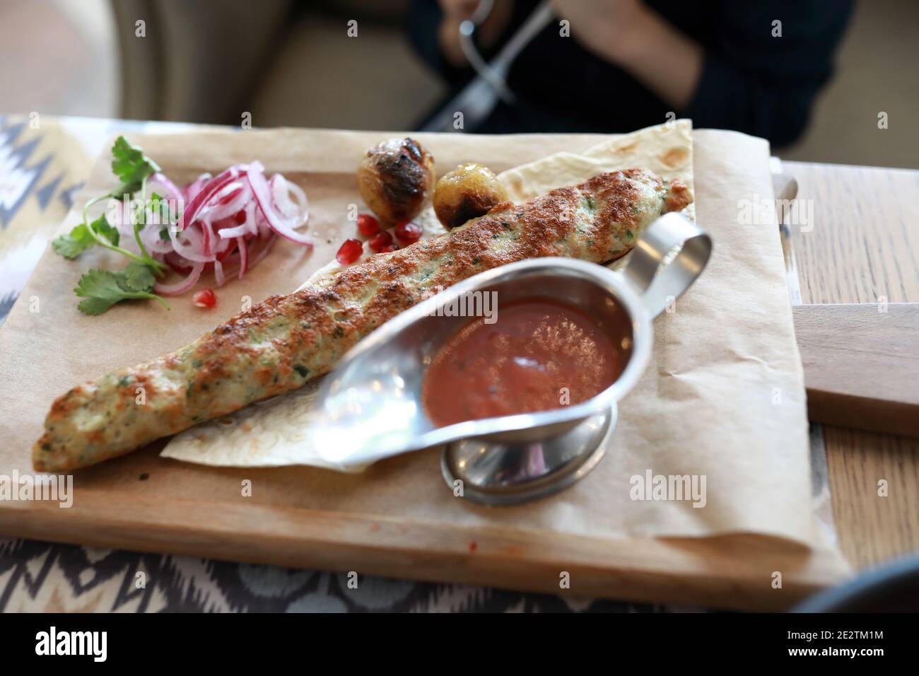 Chicken lula kebab with sauce in cafe Stock Photo - Alamy
