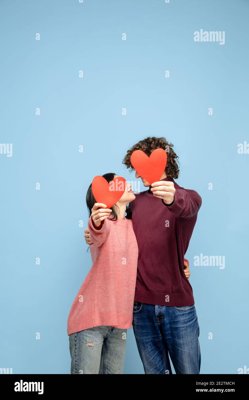 Showing hearts, flyer. Beautiful couple in love on blue studio ...