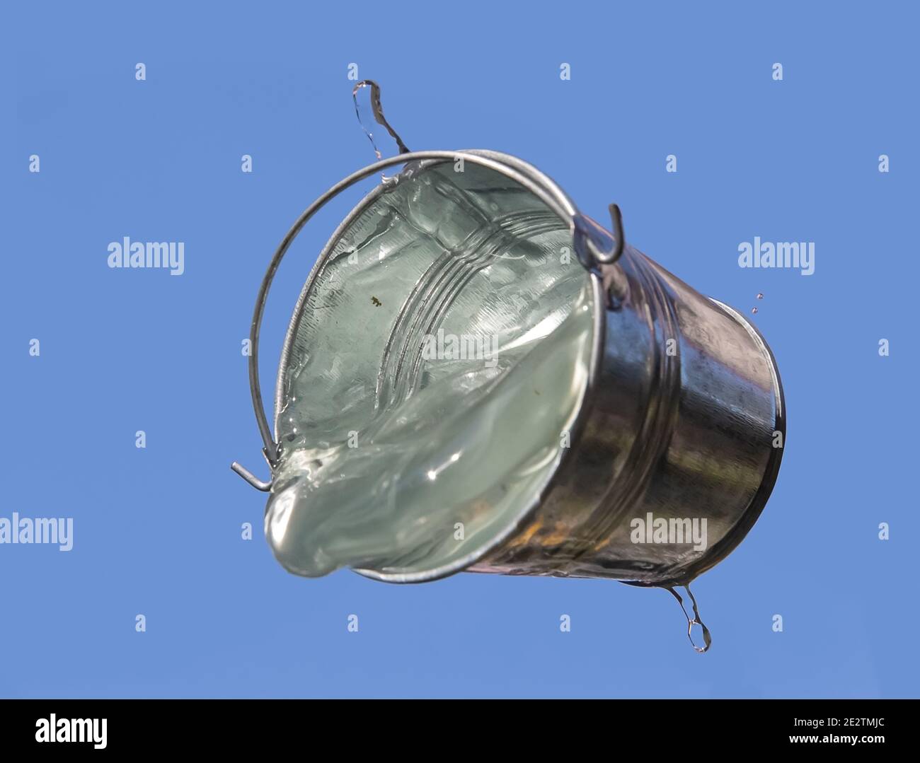 A falling buckets splashes water, on a background of blue sky Stock ...