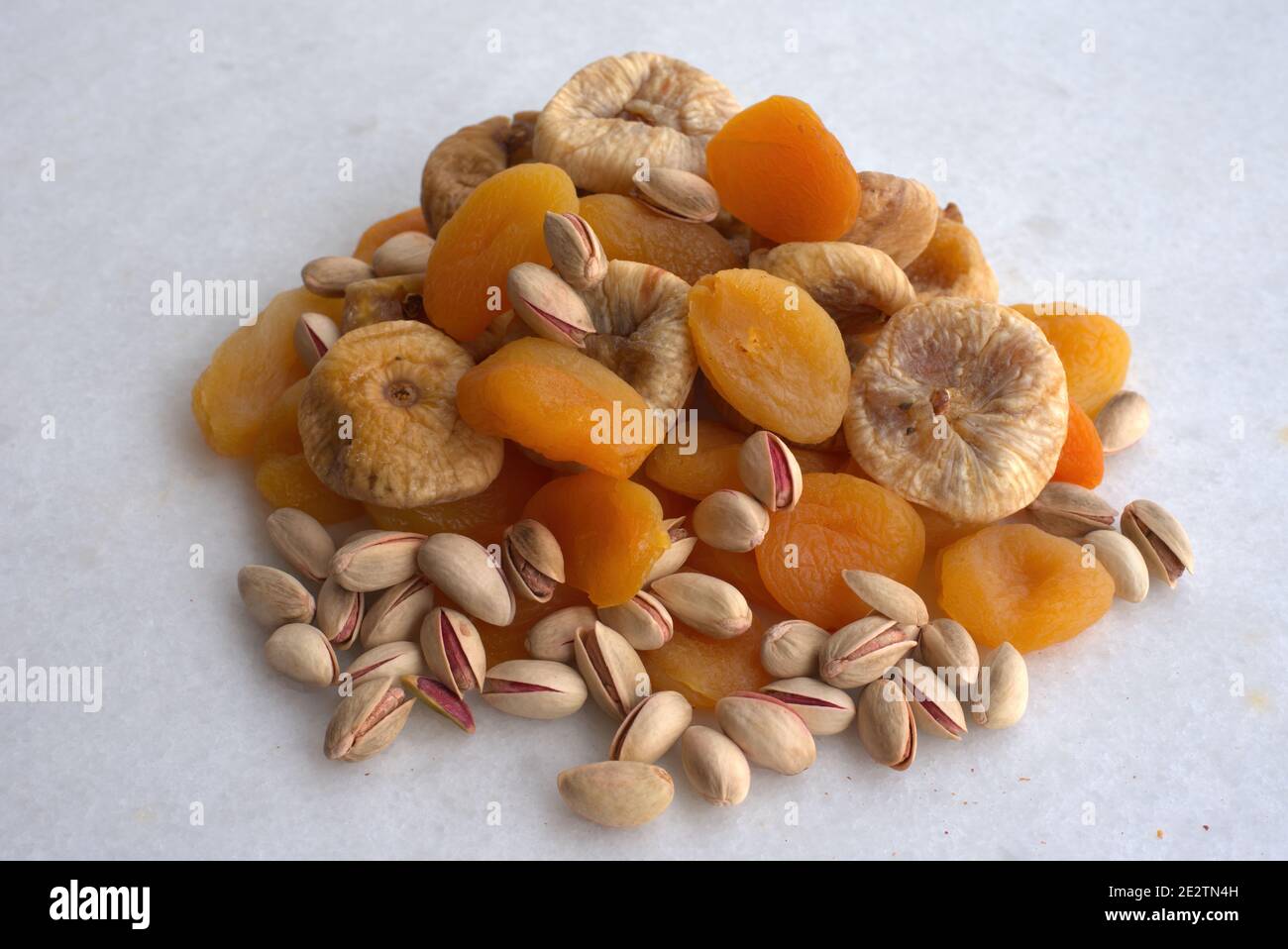 Heap of delicious dried apricots, figs, and pistachios isolated in the ...