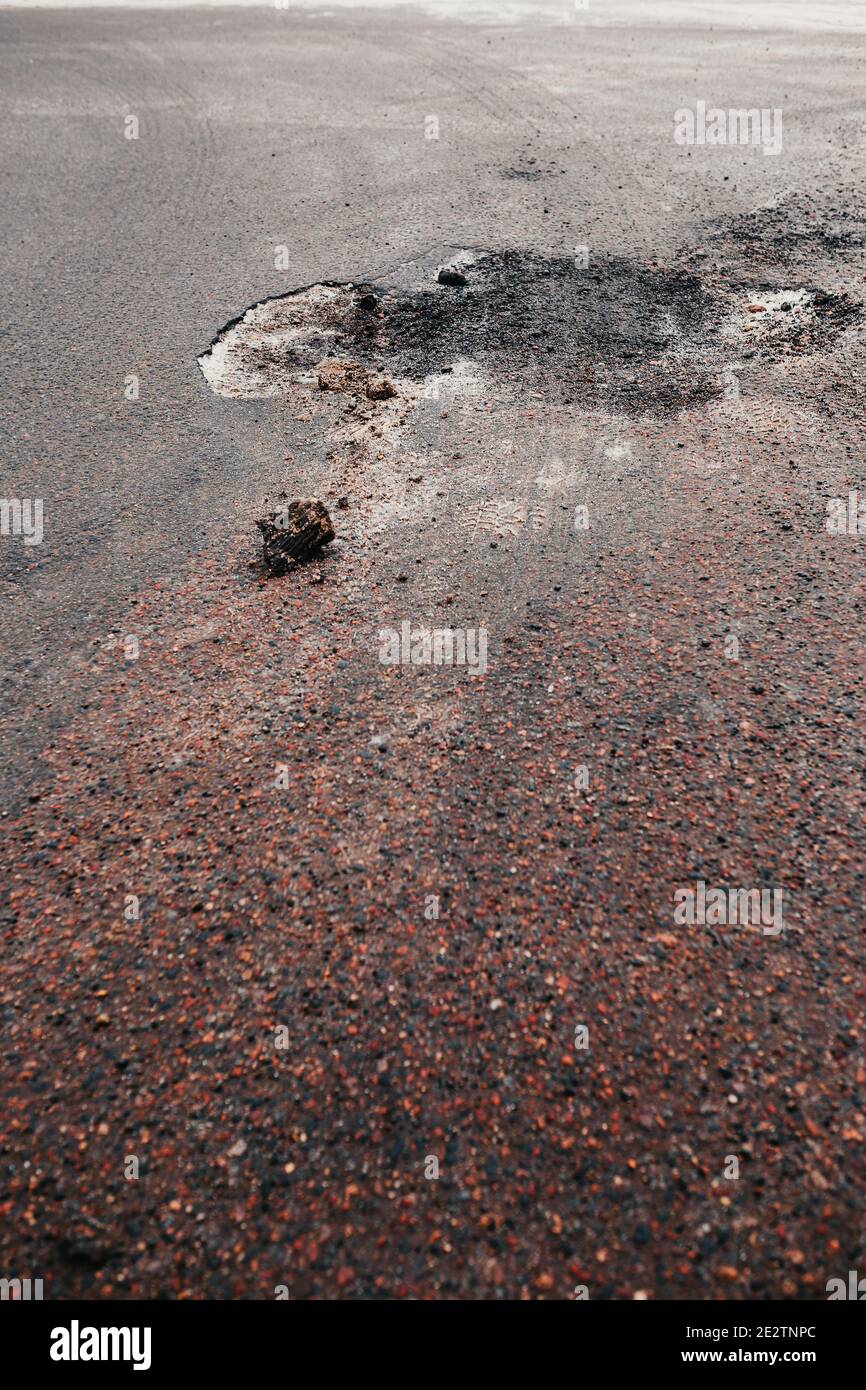 Deep hole in the asphalt on the road - damaged road surface - cold ...