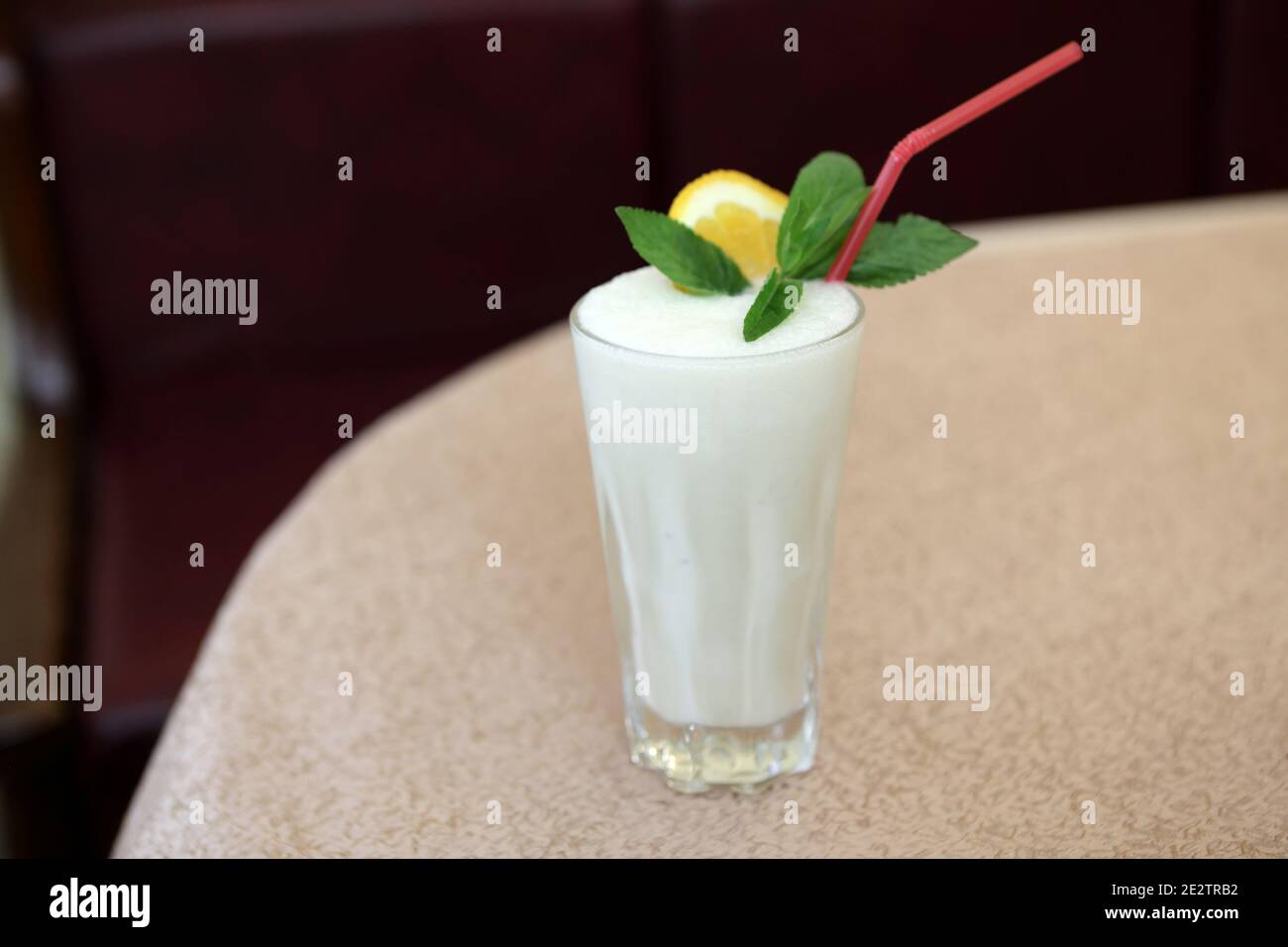 Glass of milkshake on a table in restaurant Stock Photo - Alamy