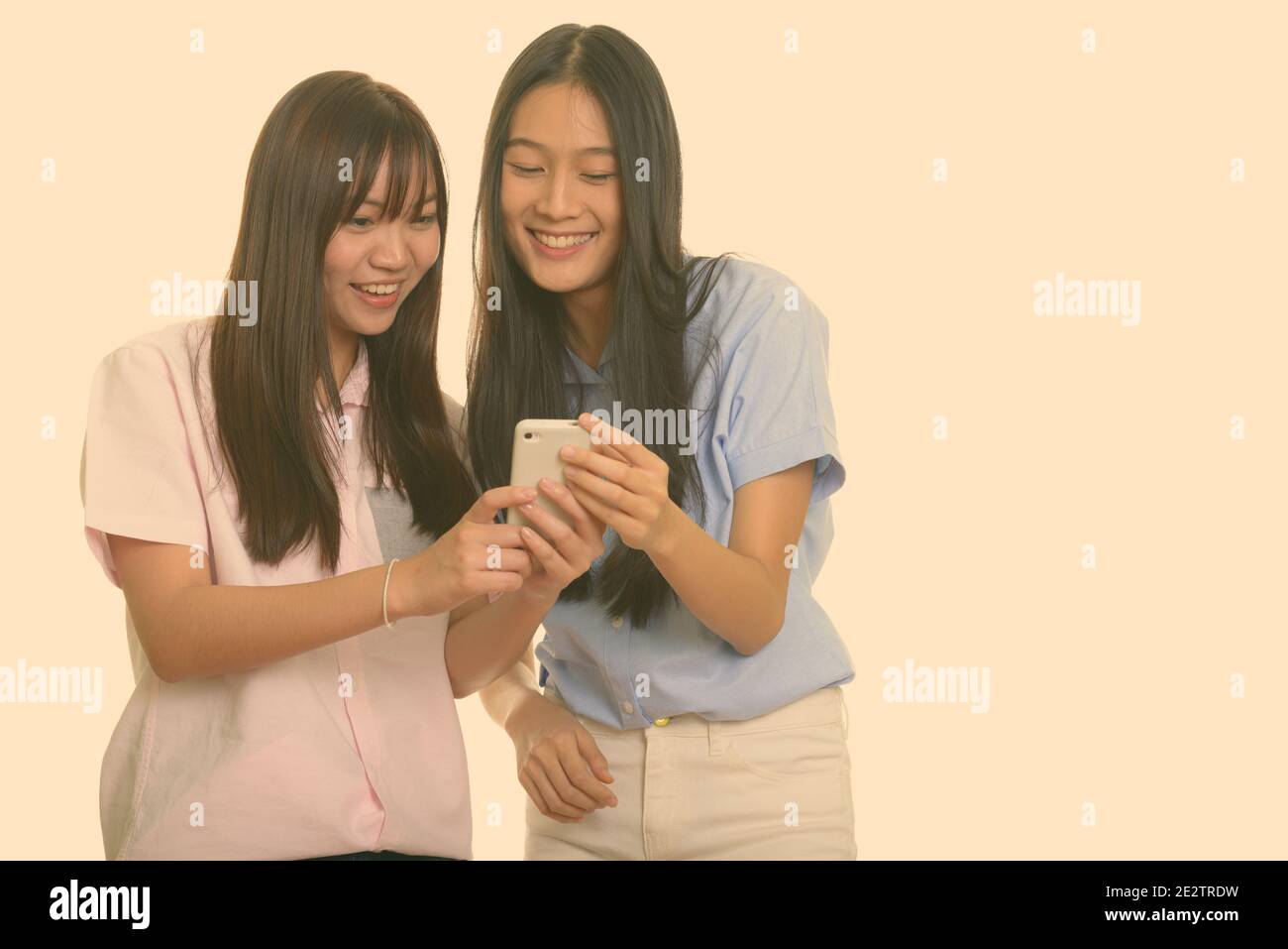 Smiling teenage girls using mobile hi-res stock photography and images ...
