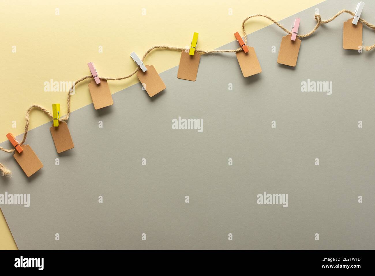 Paper tags tied with colored clothespins to jute rope, rope with tags ...