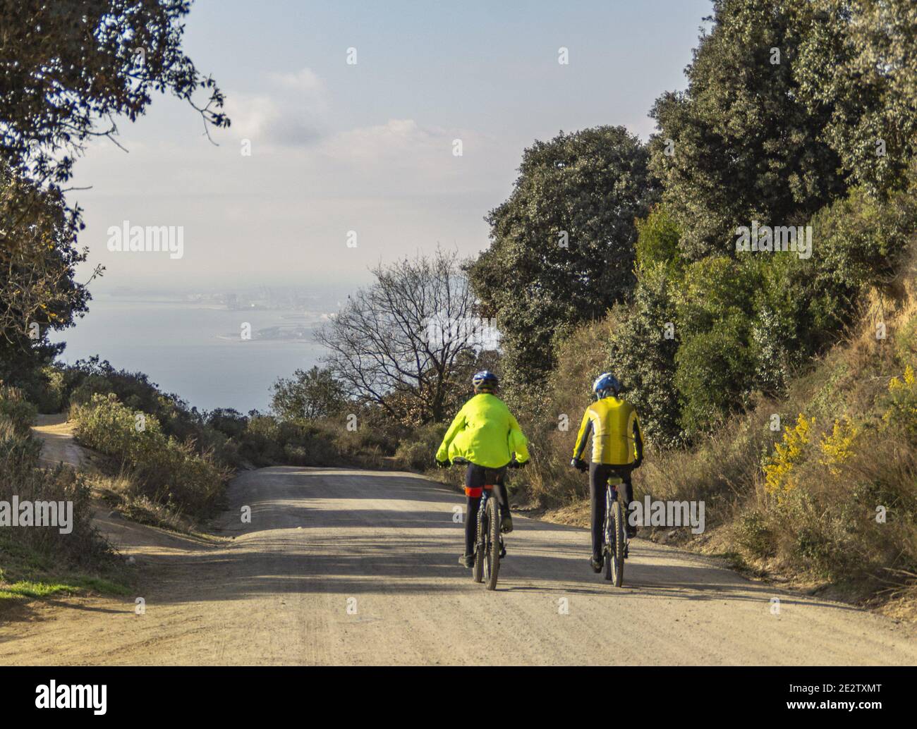 View of two mountain bikers cycling on a dirt road Stock Photo - Alamy