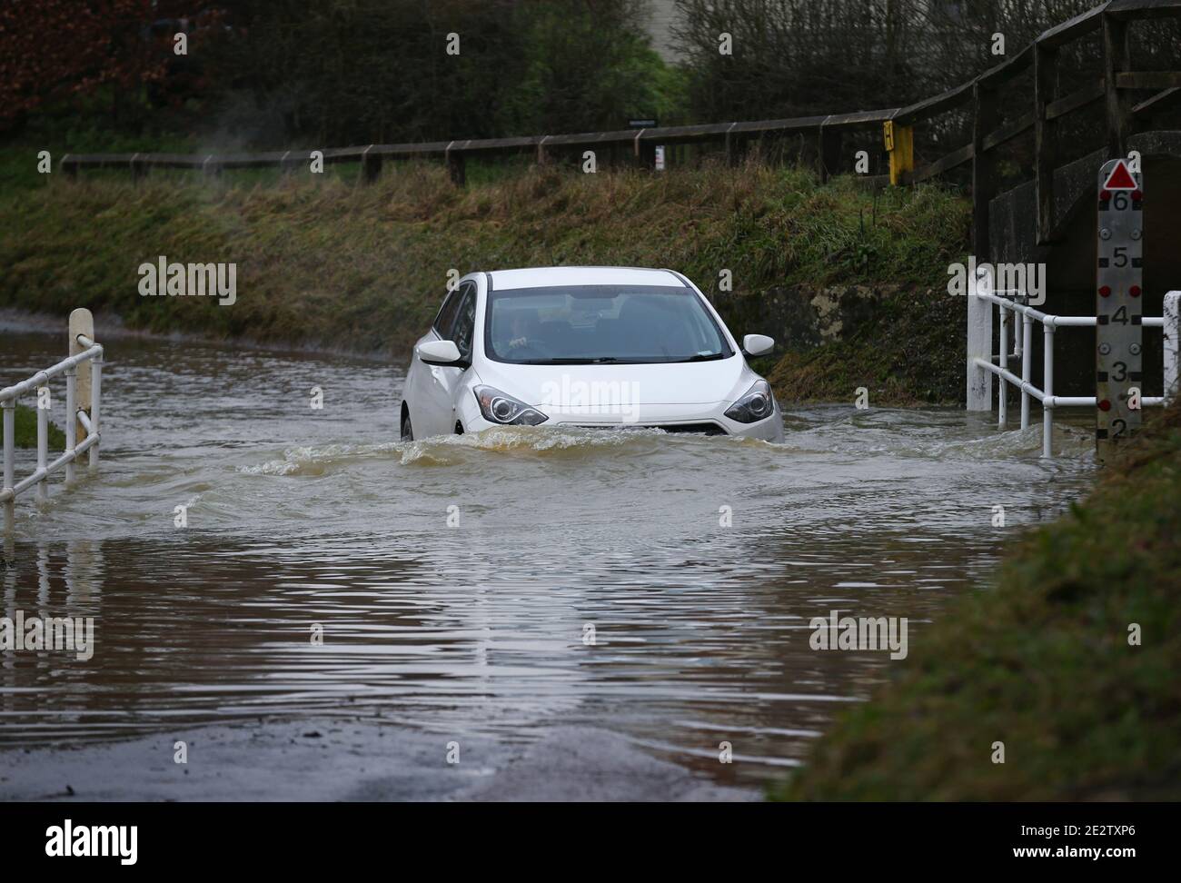 A car drives along a flooded road in the village of Great Easton ...