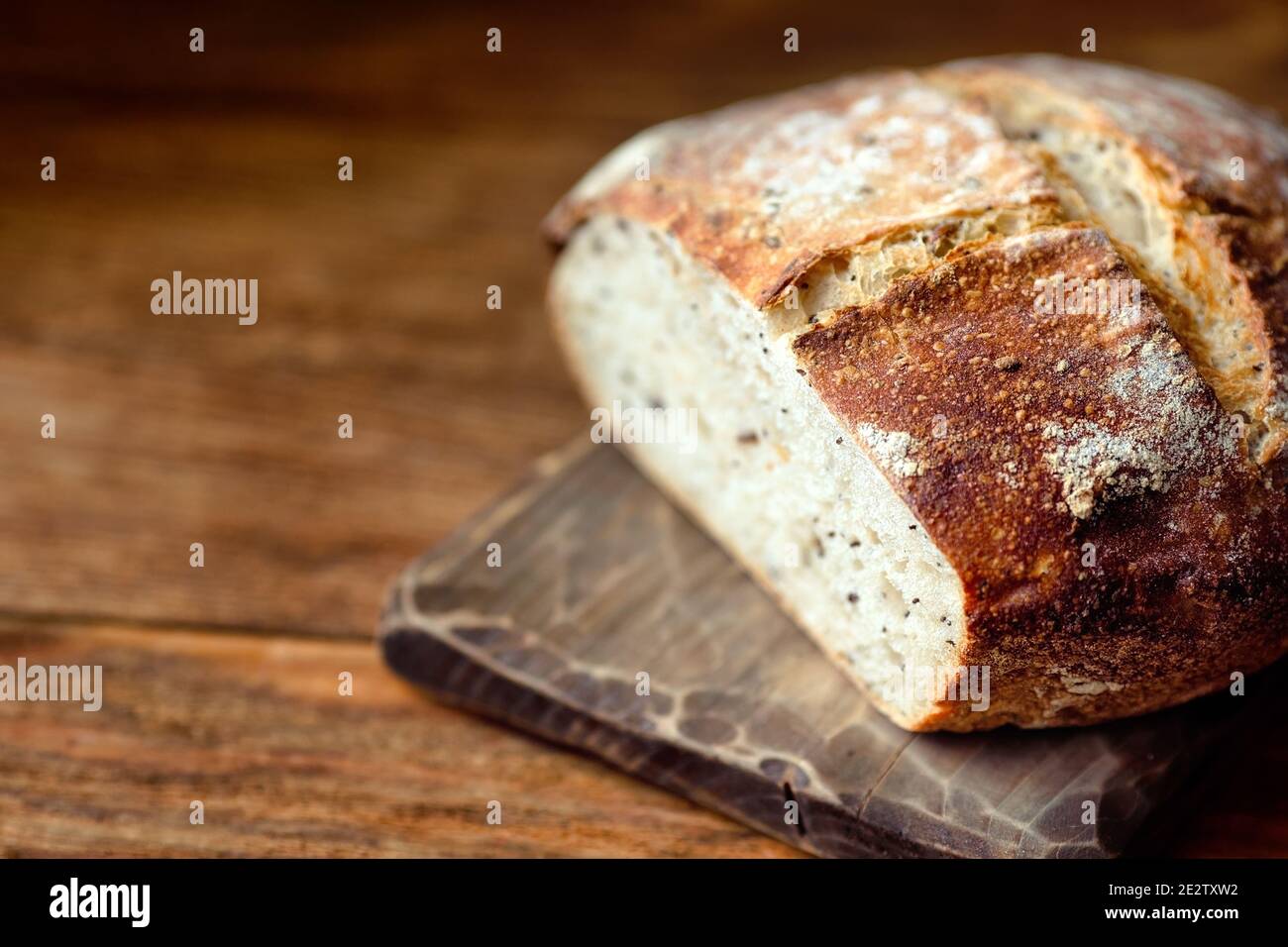 A round loaf of whole-grain homemade bread without yeast lies on a ...