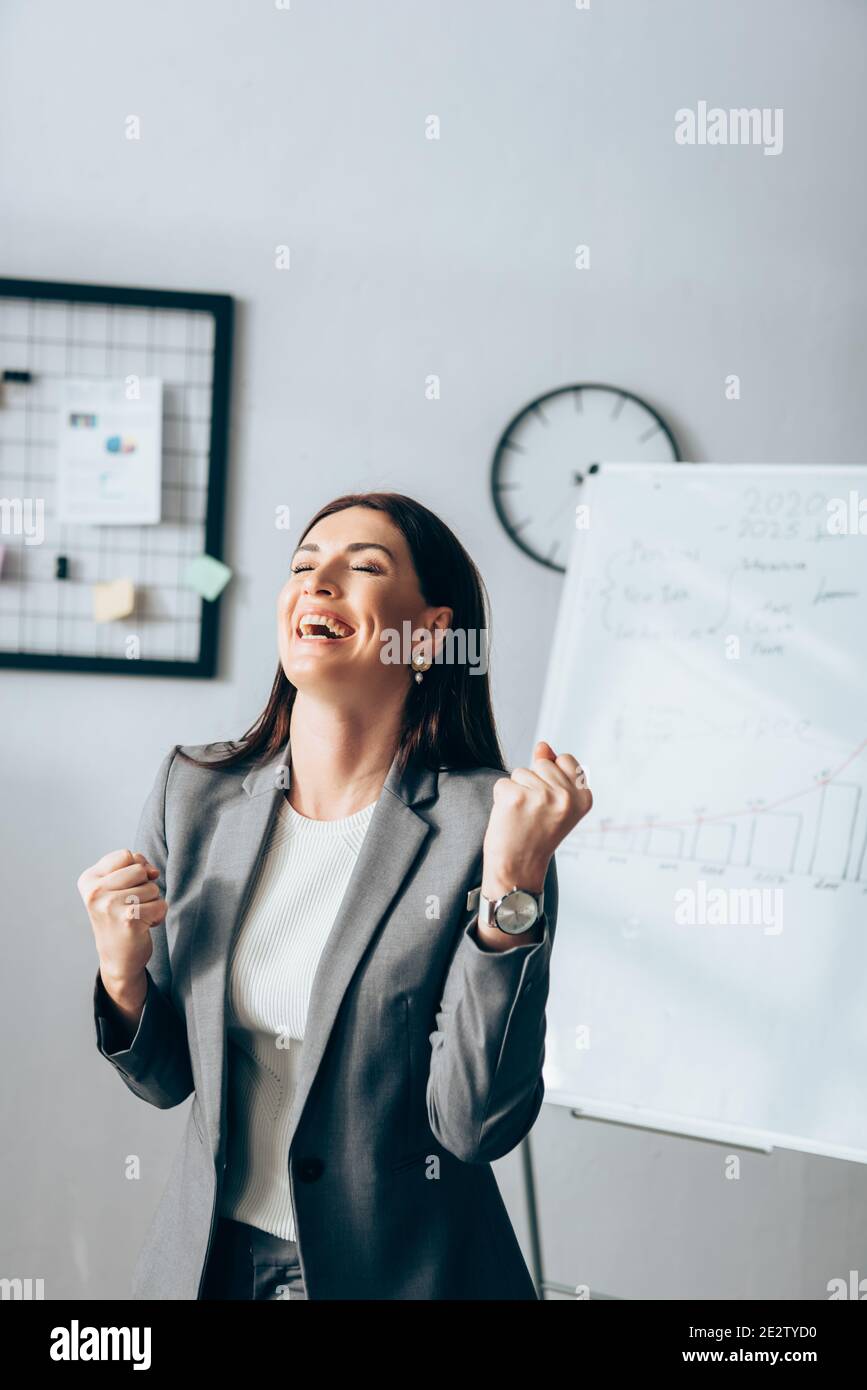Cheerful businesswoman showing yeah gesture in office Stock Photo - Alamy