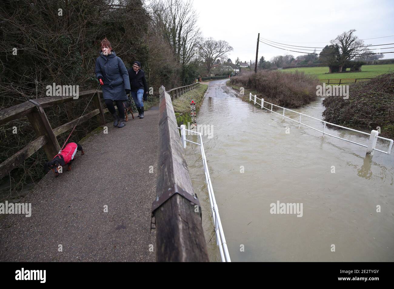 People cross a bridge over a swollen River Chelmer in the village of ...
