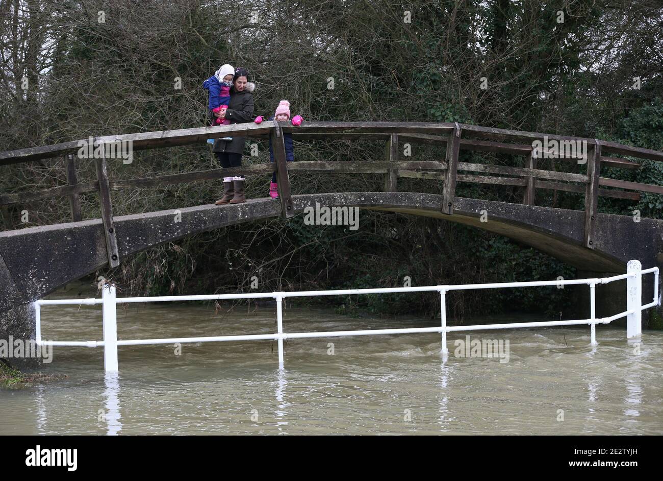People cross a bridge over a swollen River Chelmer in the village of ...