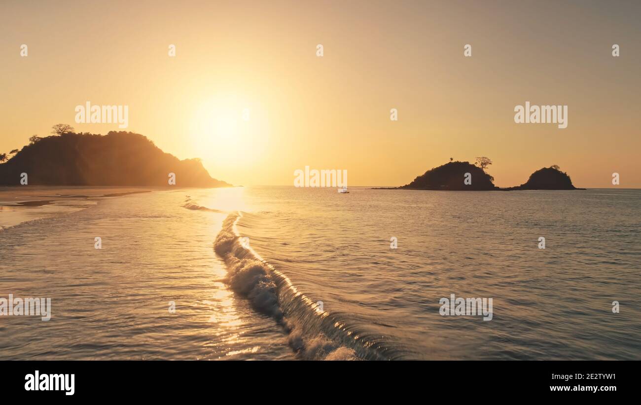 Sun reflection at waves of ocean bay aerial. Silhouette of mountains ...