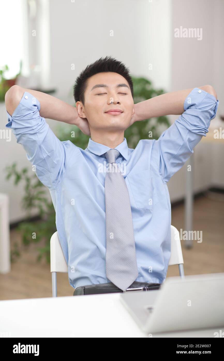 Portrait of young businessman relaxing in front of laptop high quality ...