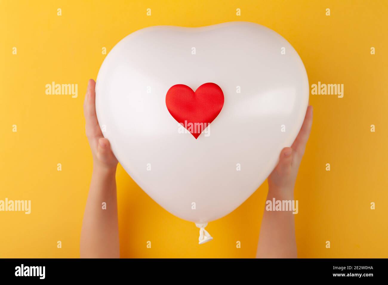 Children hands holding white balloon heart shape, love and valentines ...