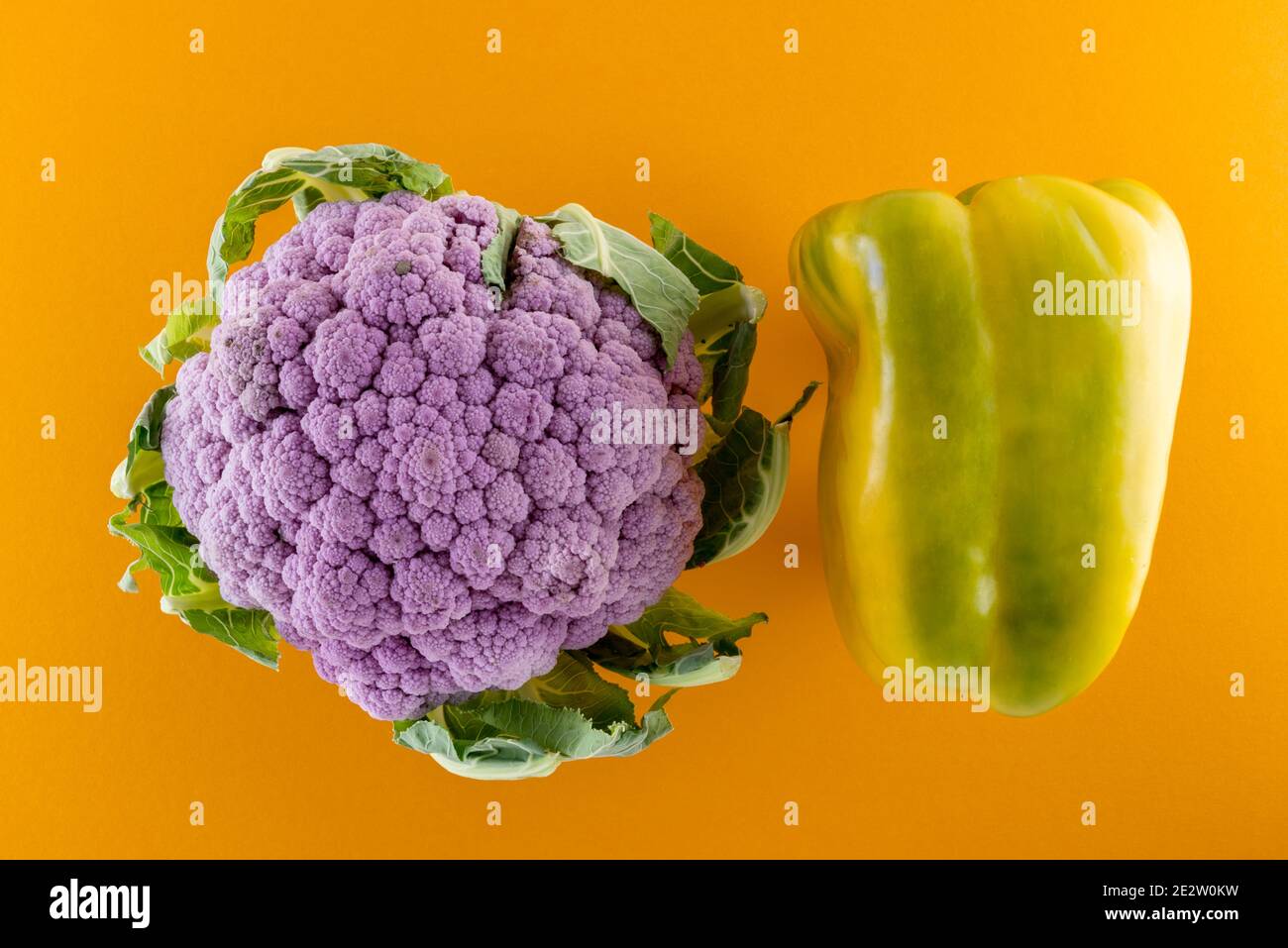 Purple cauliflower and bell pepper isolated on orange color background ...