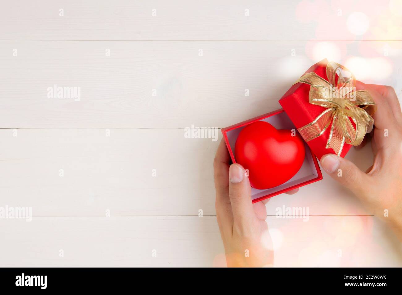 Valentine day, hand open red gift box with heart shape on wooden white ...