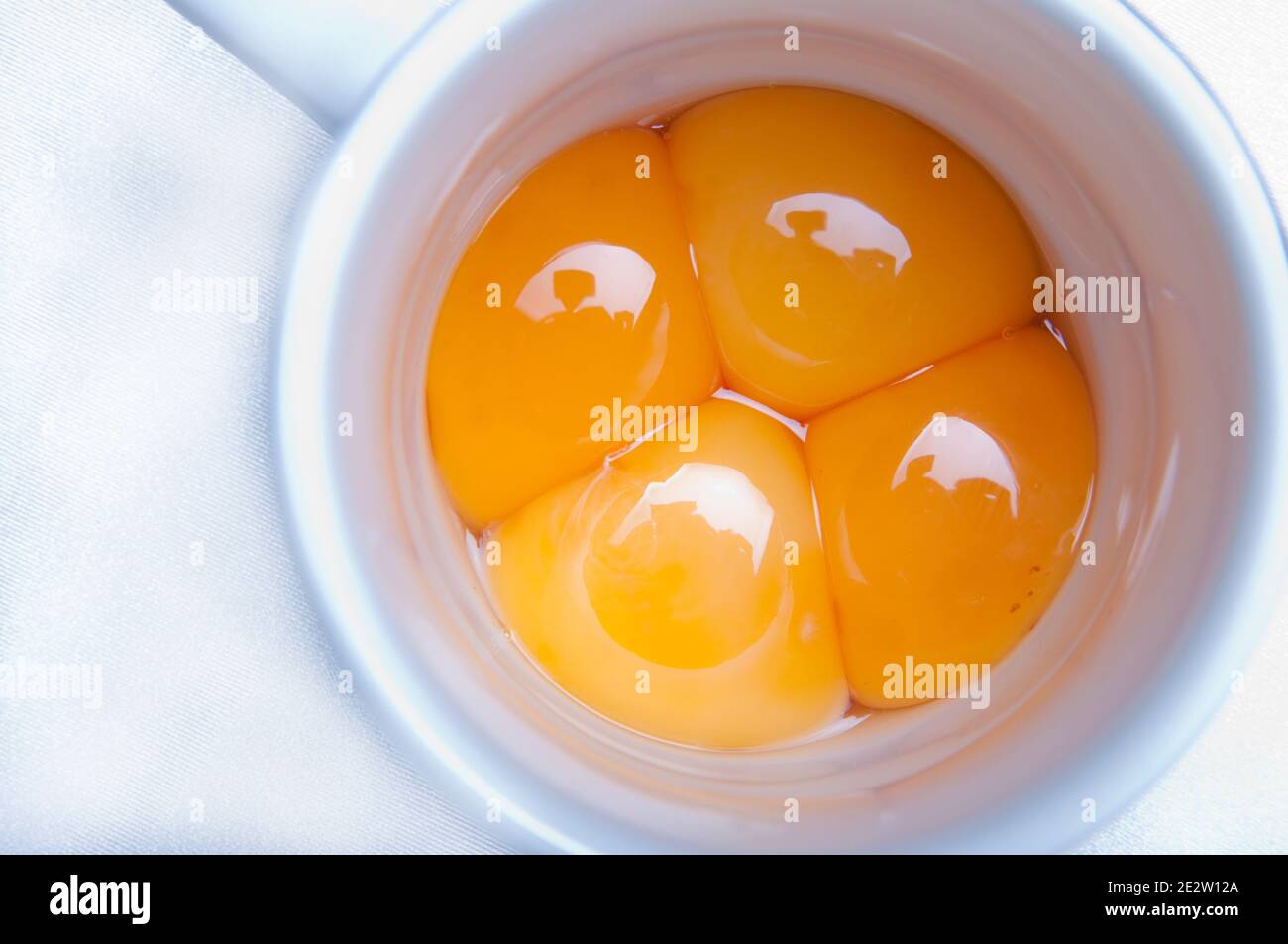 Four fresh eggs to be mixed with white background Stock Photo - Alamy