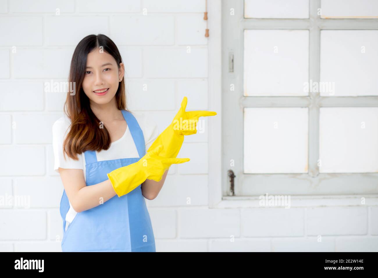 Portrait young asian woman is housekeeper in rubber gloves and apron ...