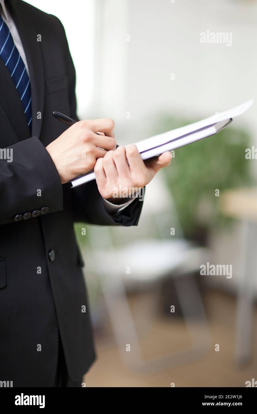 Portrait of young businessman writing in office,close-up high quality ...