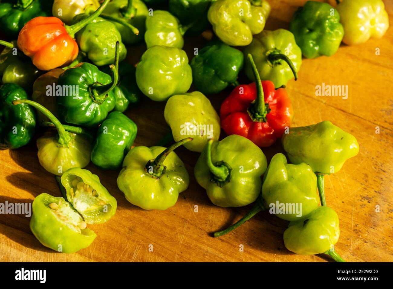 Close up photo of a bunch of tropical chilli on a wooden surface, there ...