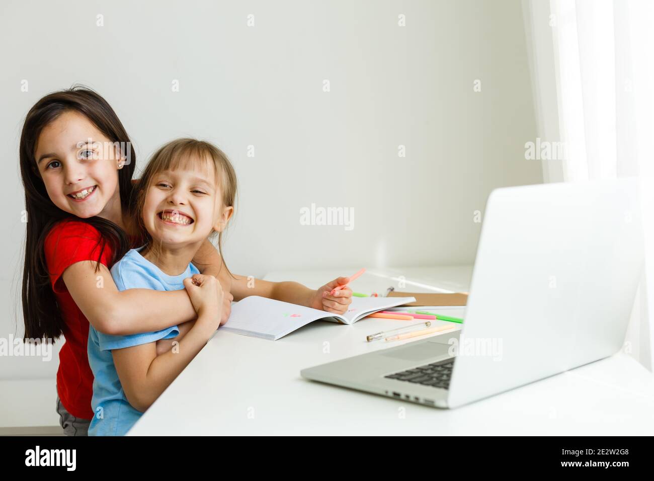 Two cute little sisters study together at home. Education for kids ...