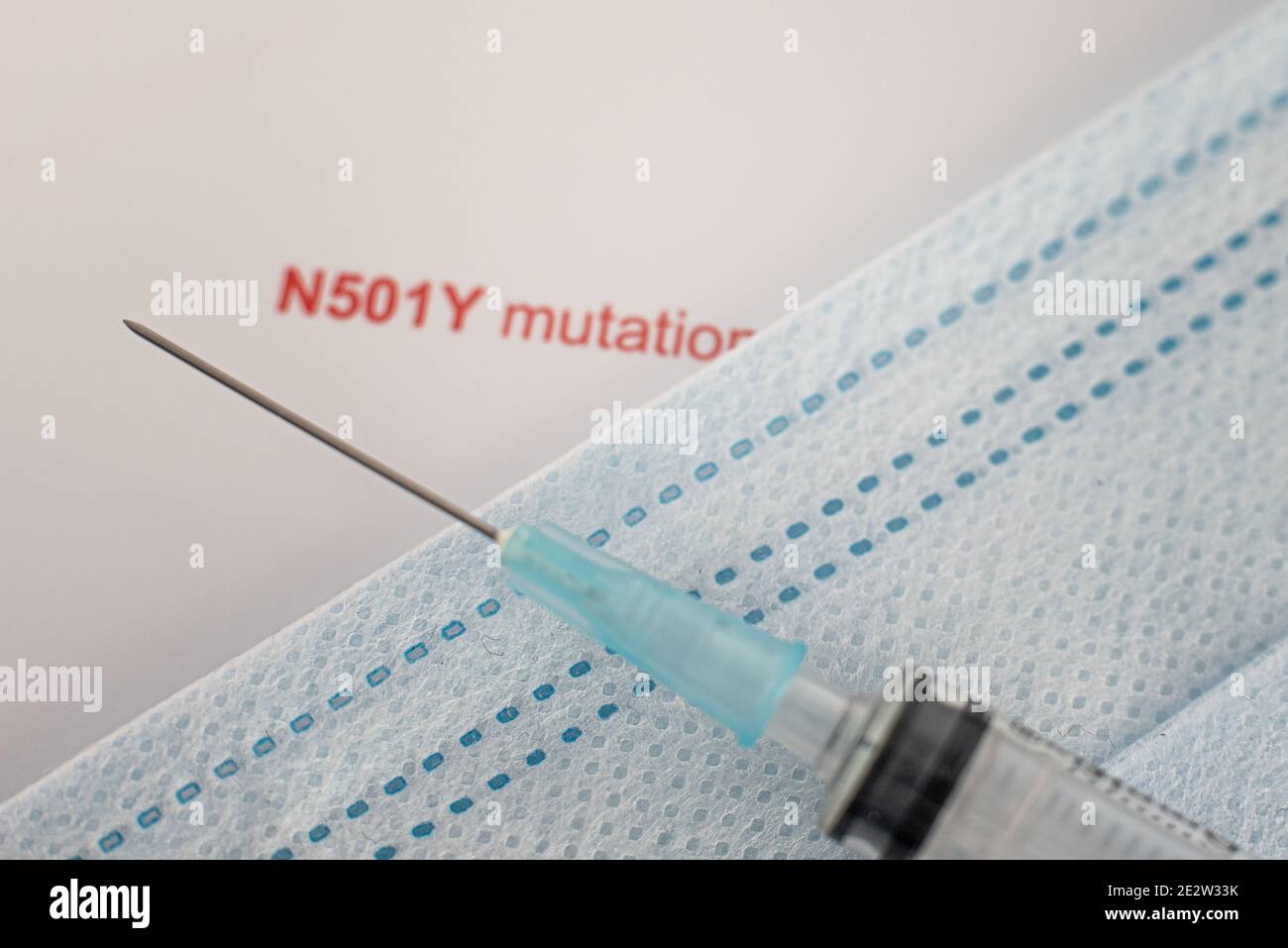 The english mutated virus N501Y and a Syringe and a face mask on white ...