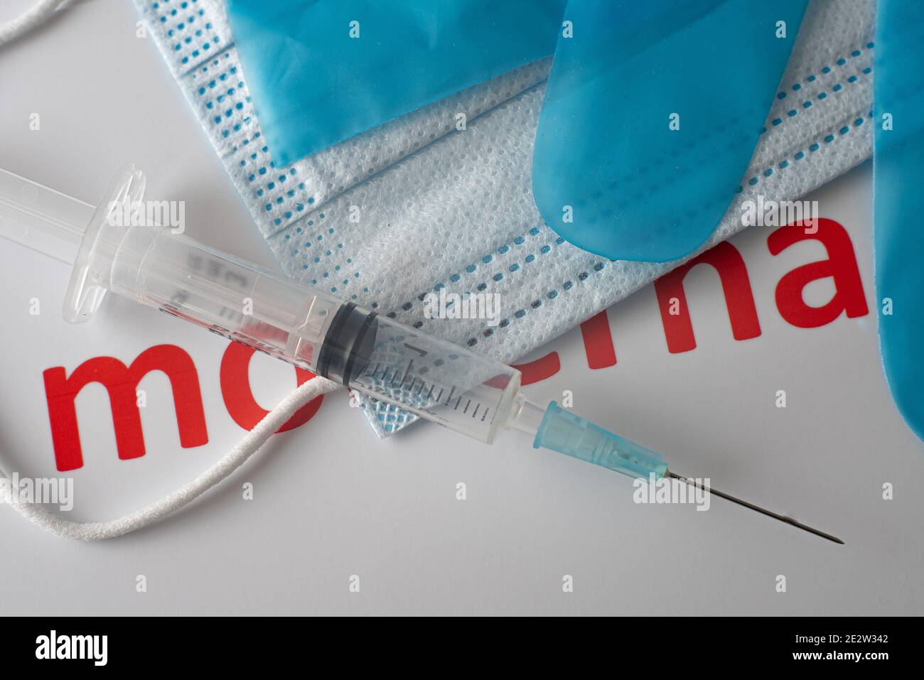 Red moderna sign an a blue syringe and a face mask and the moderna logo ...