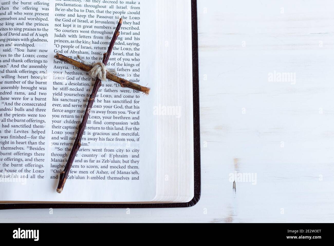 open bible with rustic wood cross and copy space on white background ...
