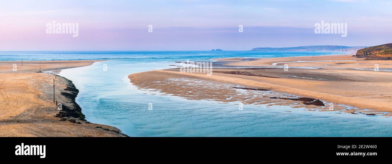 Panoramic shot of sunset colours and flowing river at Porthkidney Beach ...