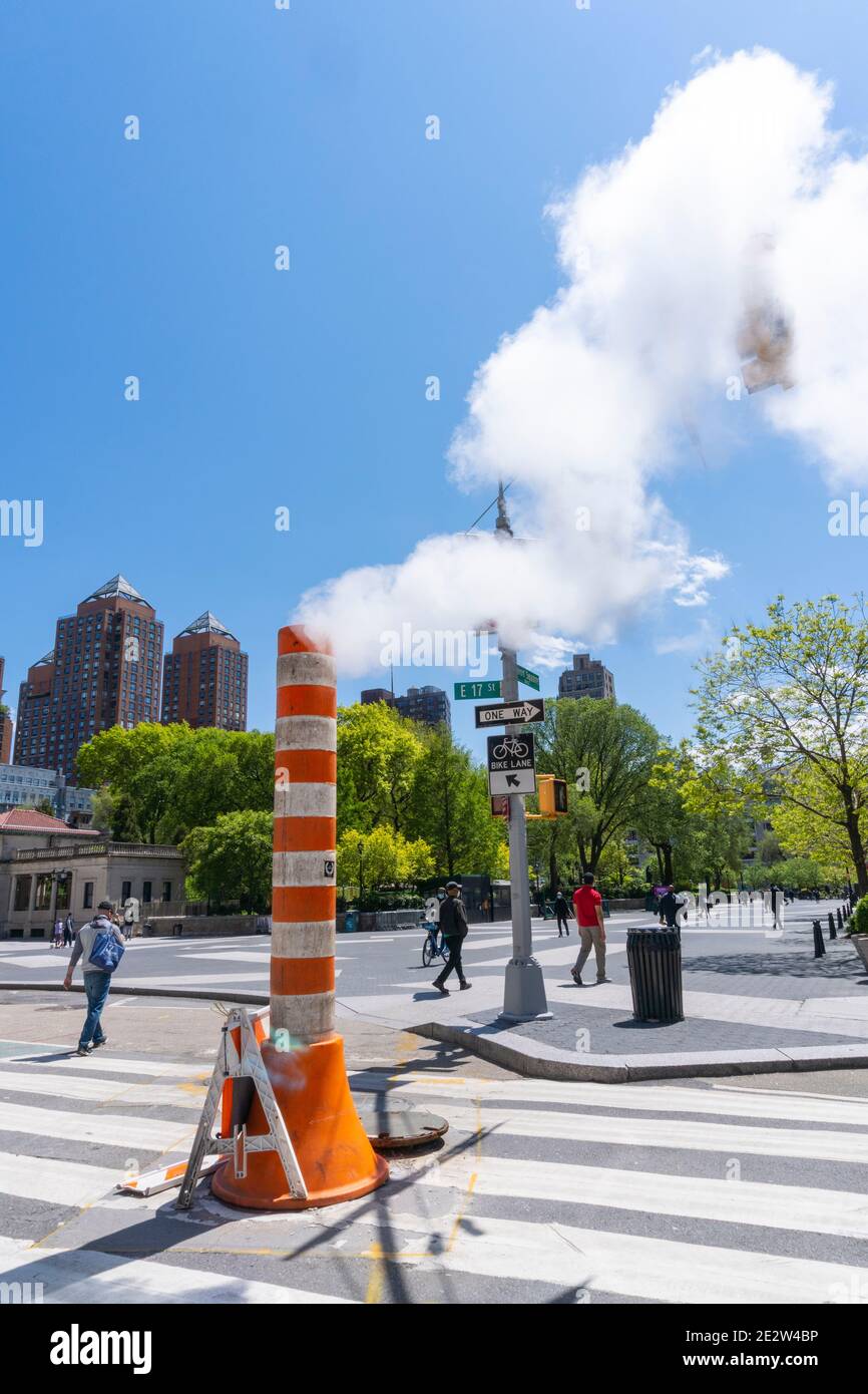 Steam rises and drifts in the blue sky around the Union Square NYC ...