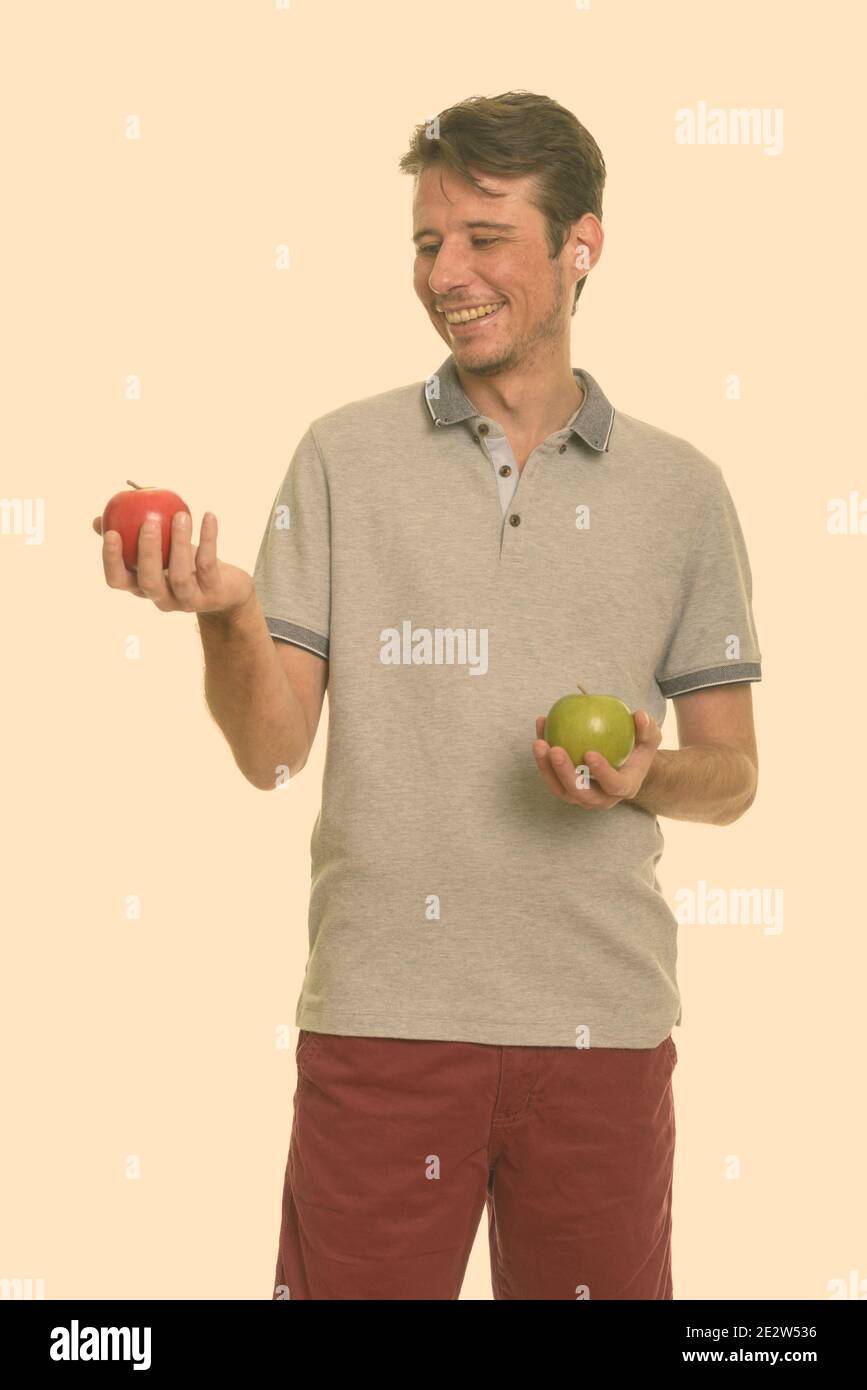 Happy Caucasian man holding red and green apple Stock Photo - Alamy