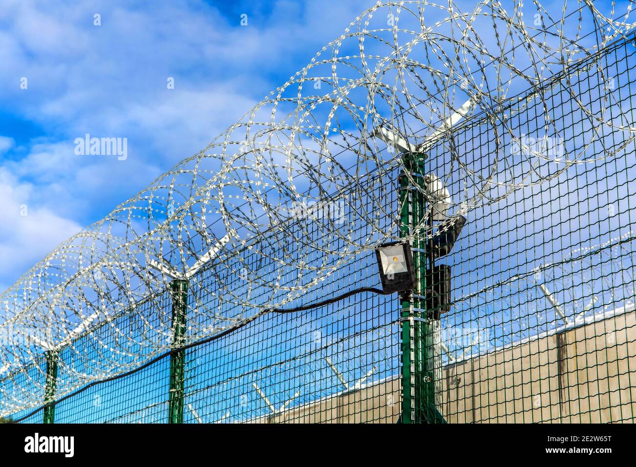 Restricted area - fence with barbed wire. Razor wire jail fence ...