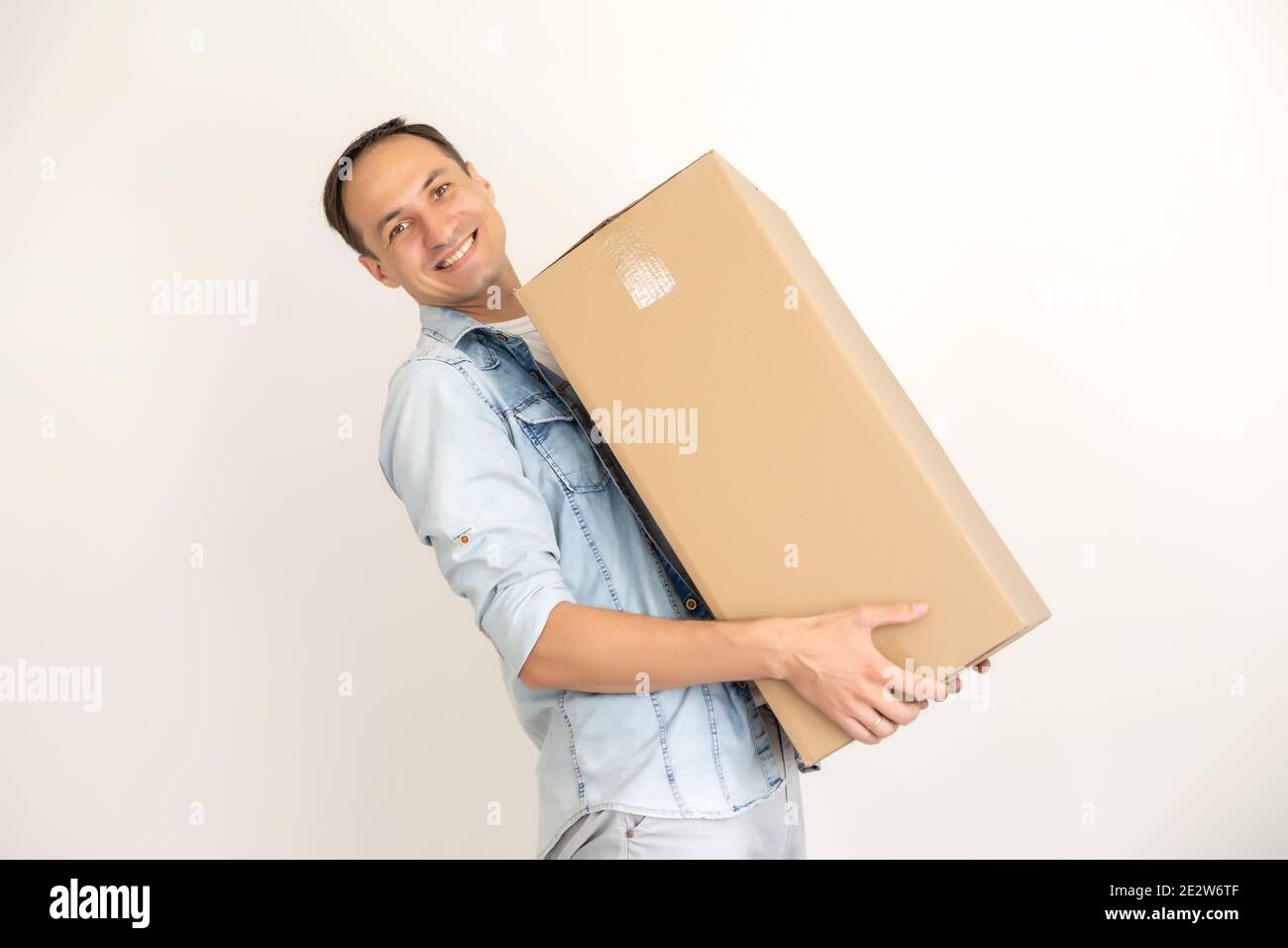 smiling delivery man holding a big parcel isolated on white Stock Photo ...