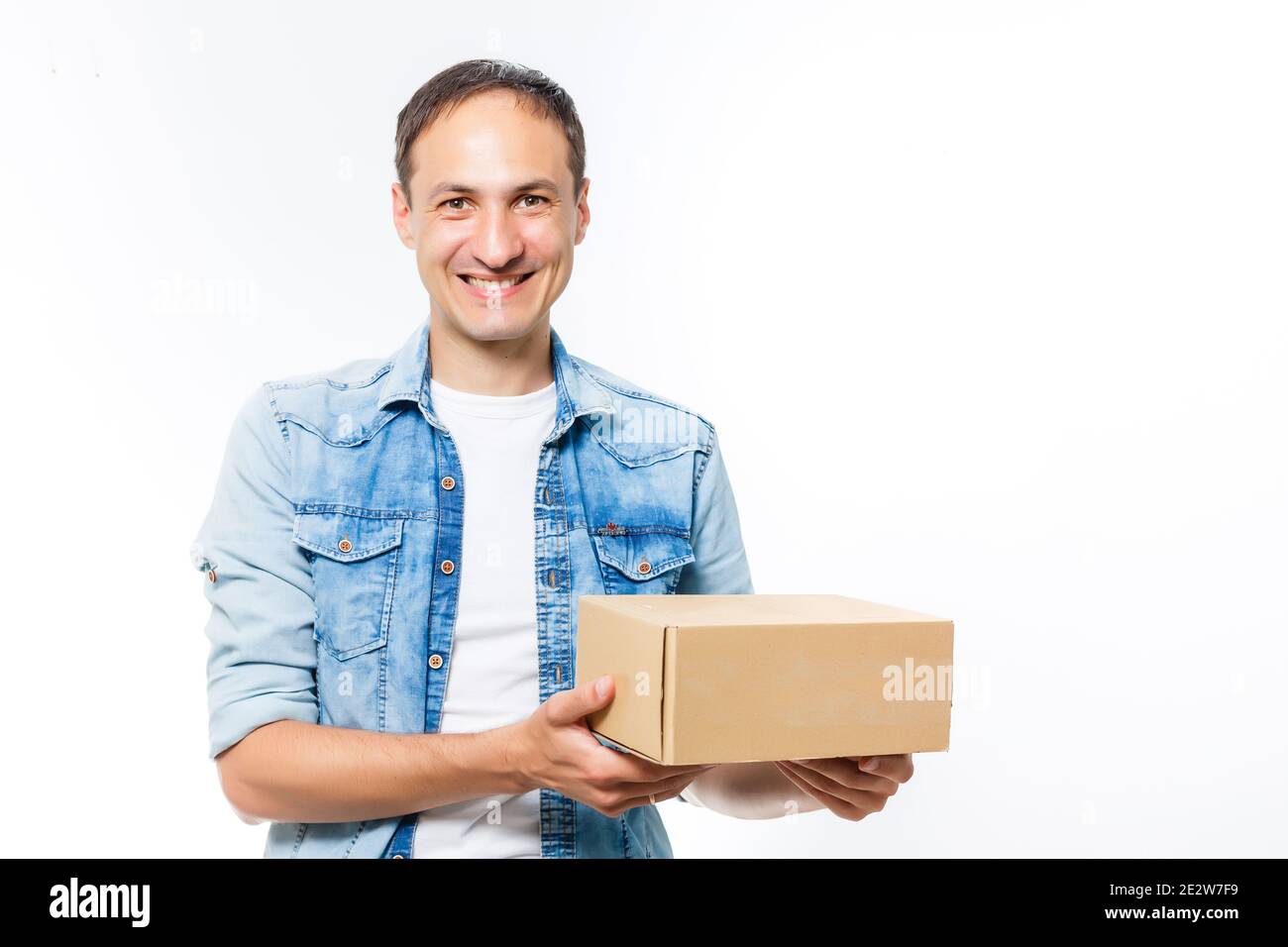 smiling delivery man holding a big parcel isolated on white Stock Photo ...
