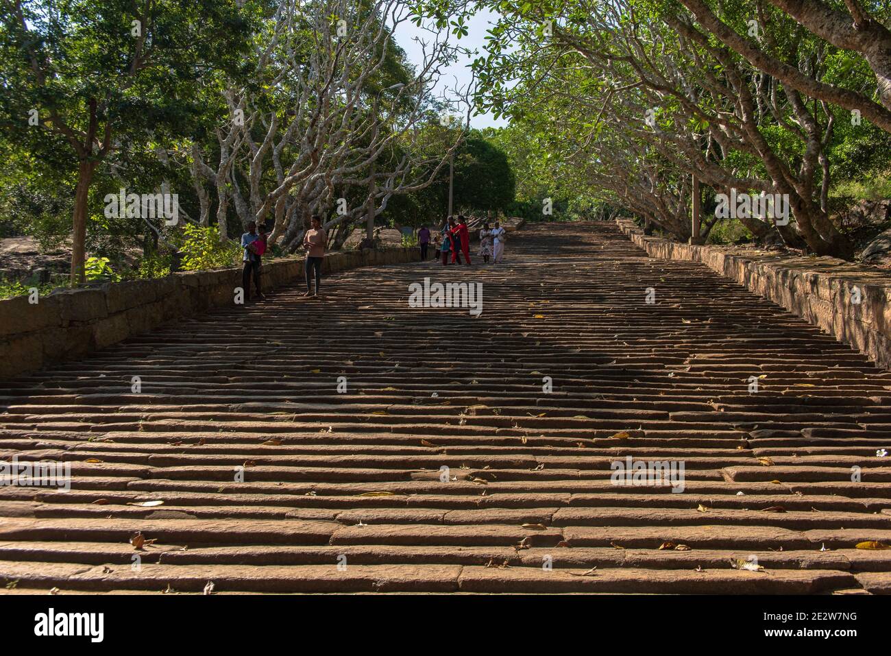 People walking on stone stairs leading up to Buddhist monastery of ...