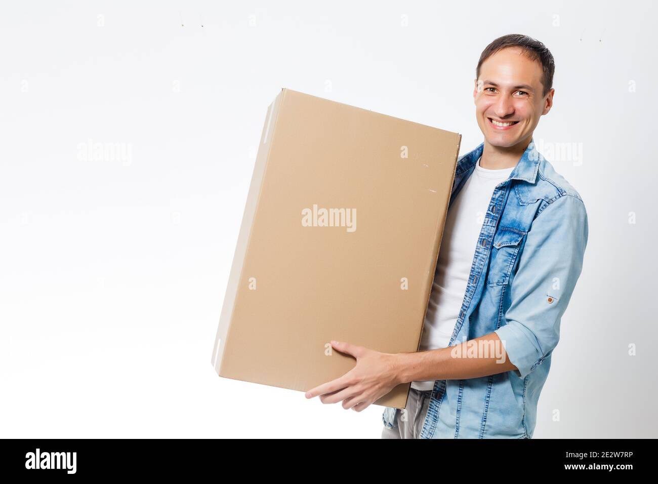 Smiling delivery man giving cardbox on white background Stock Photo - Alamy