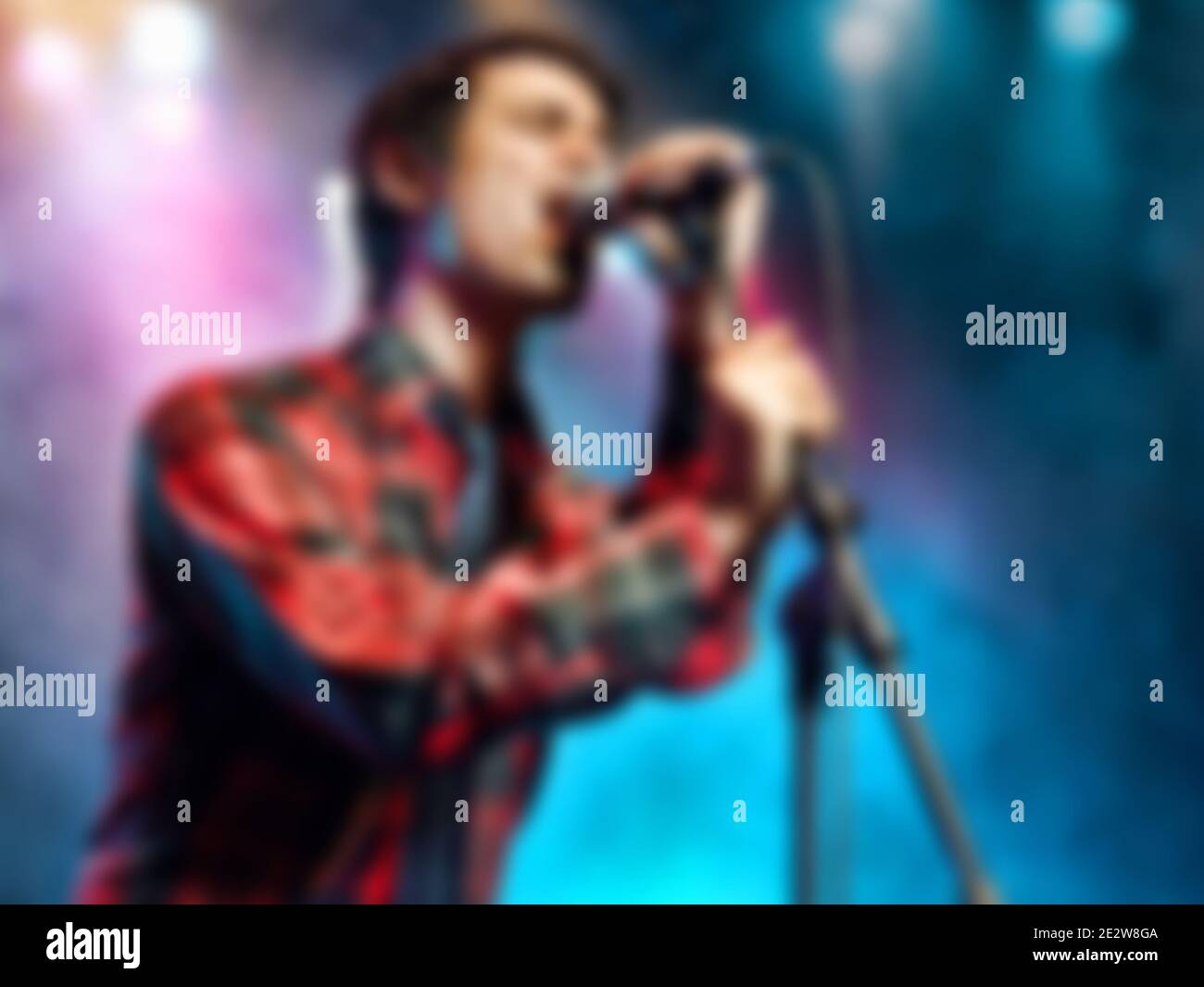 Young man singing into microphone on stage Stock Photo - Alamy