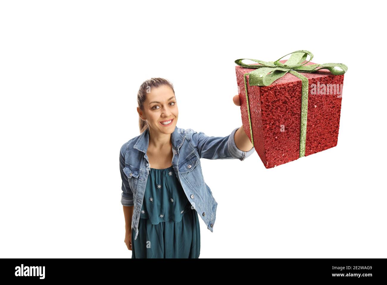 Young woman holding a sparkly red present in front of camera isolated ...