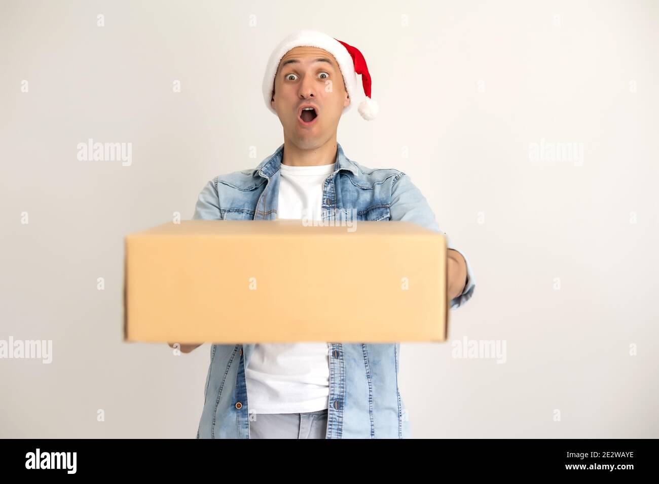 Laughing delivery man in santa claus hat on the phone, standing and ...