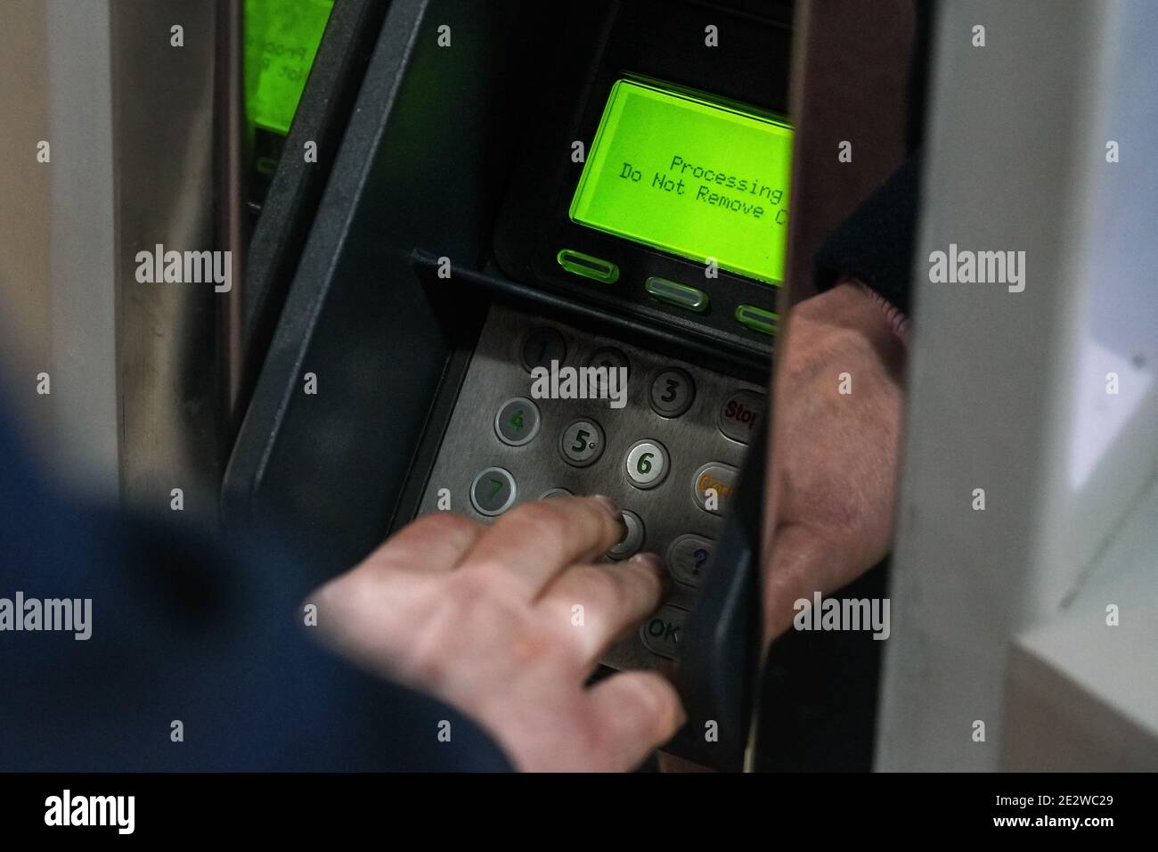 ATM or credit paying terminal with green display showing "Processing do ...