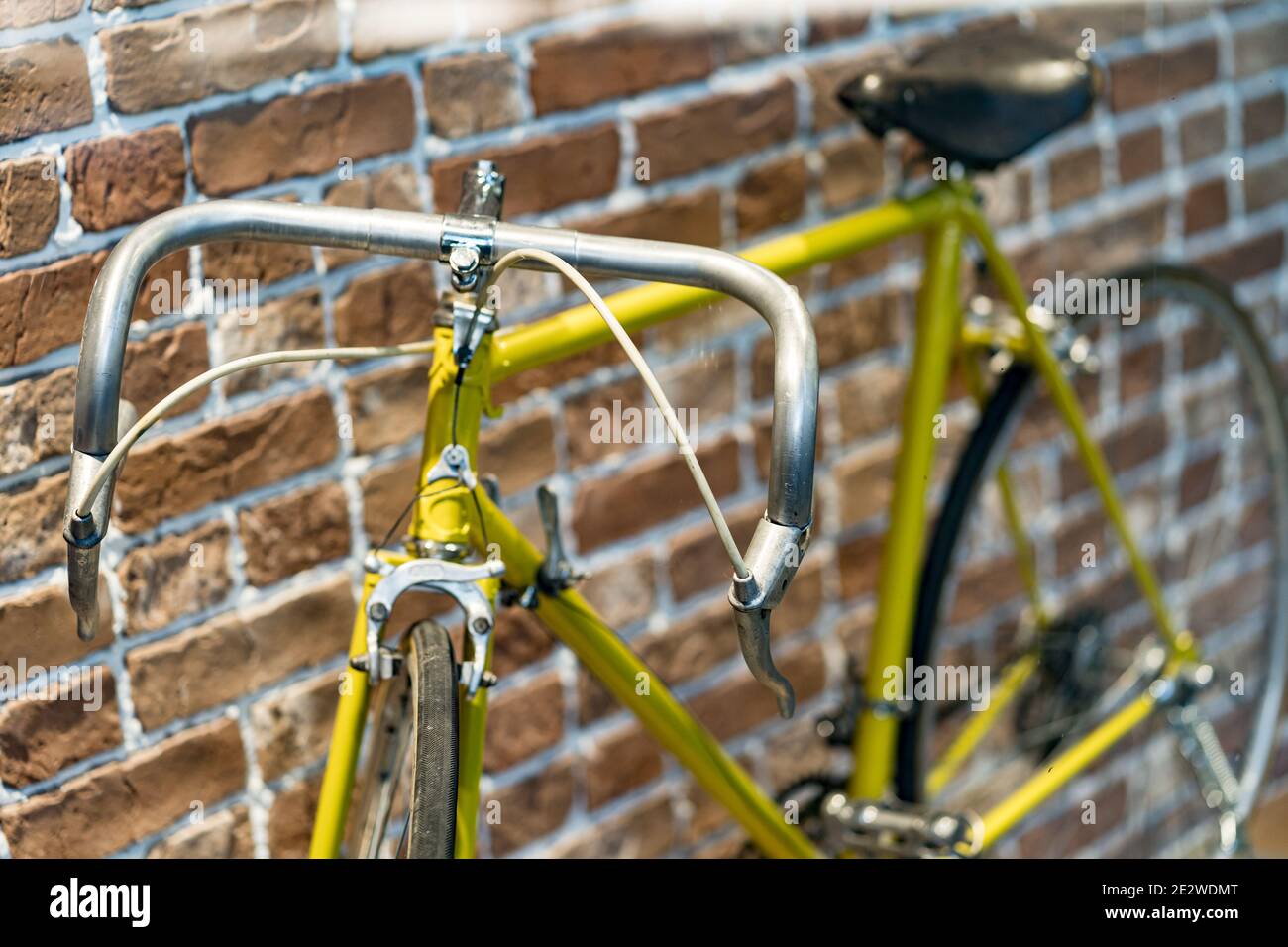 Retro yellow bicycle on roadside with vintage brick wall background ...